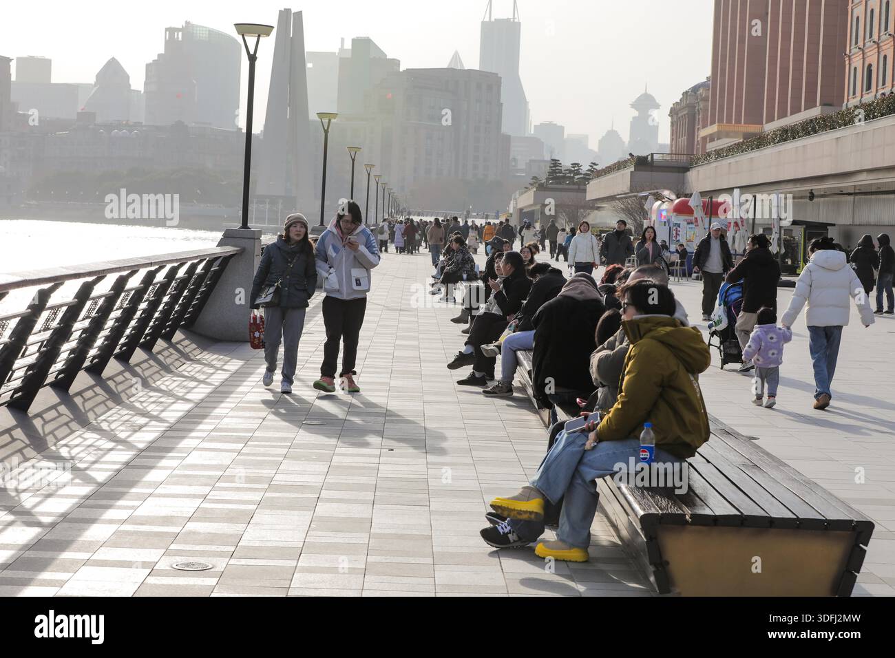 Tourists stroll along the riverside walkway in Hongkou District ...