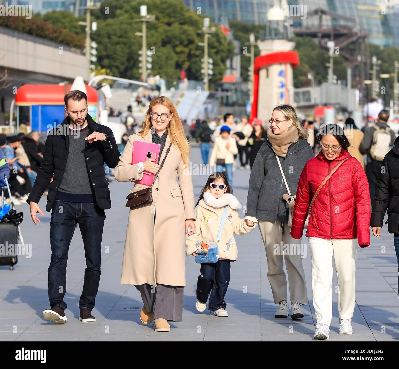Tourists stroll along the riverside walkway in Hongkou District ...