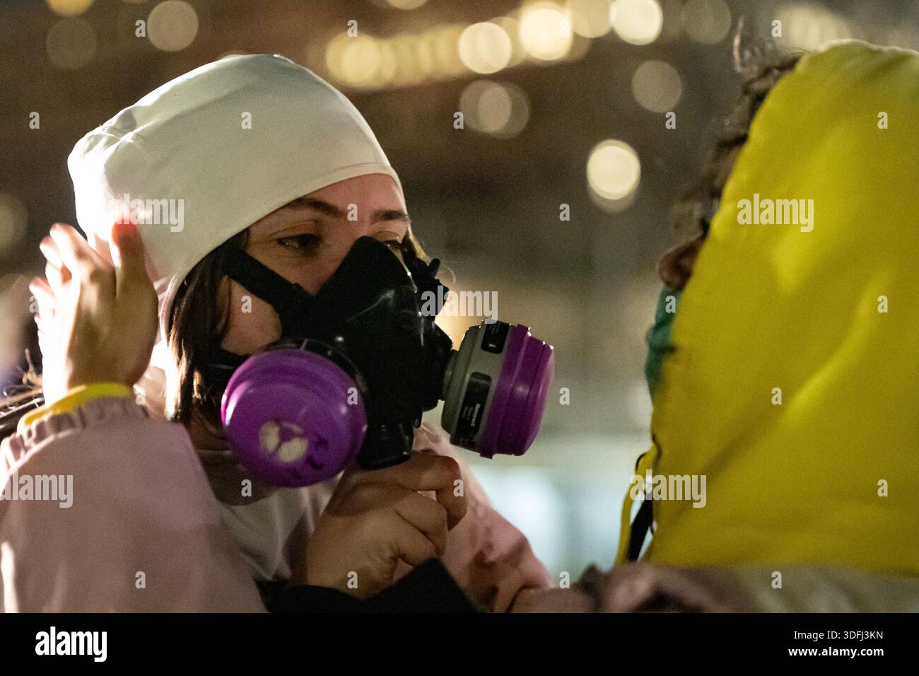 Protesters don gas masks during a demonstration outside Bishop Whipple ...