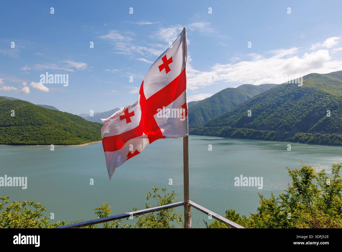 Scenic view of Georgian flags waving in front of the Zhinvali Reservoir ...