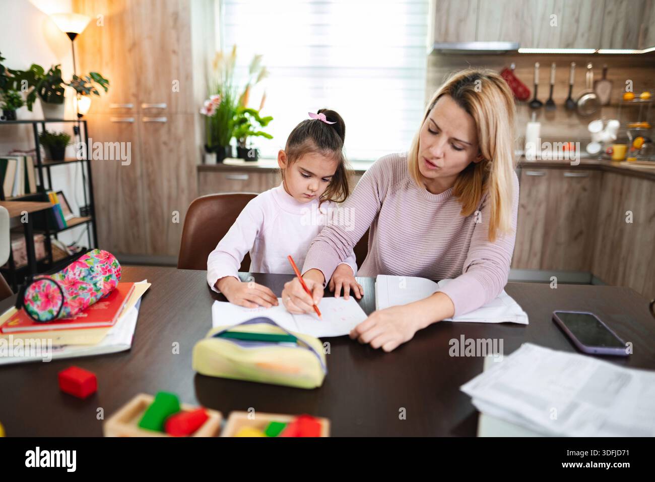 Engaging study session between a mother and daughter at home Stock ...