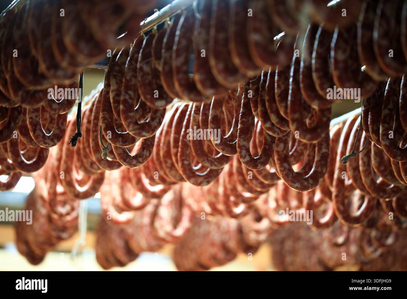 Vendors display and sell traditional cured meats including sausages ...