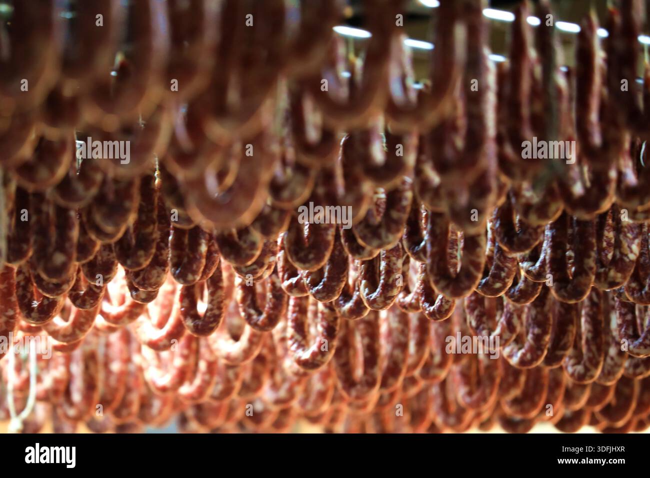 Vendors display and sell traditional cured meats including sausages ...