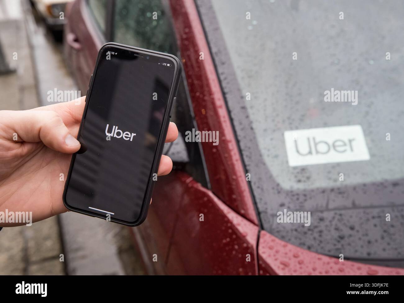 The Uber app is seen on an iPhone near a driver's vehicle in Vancouver ...