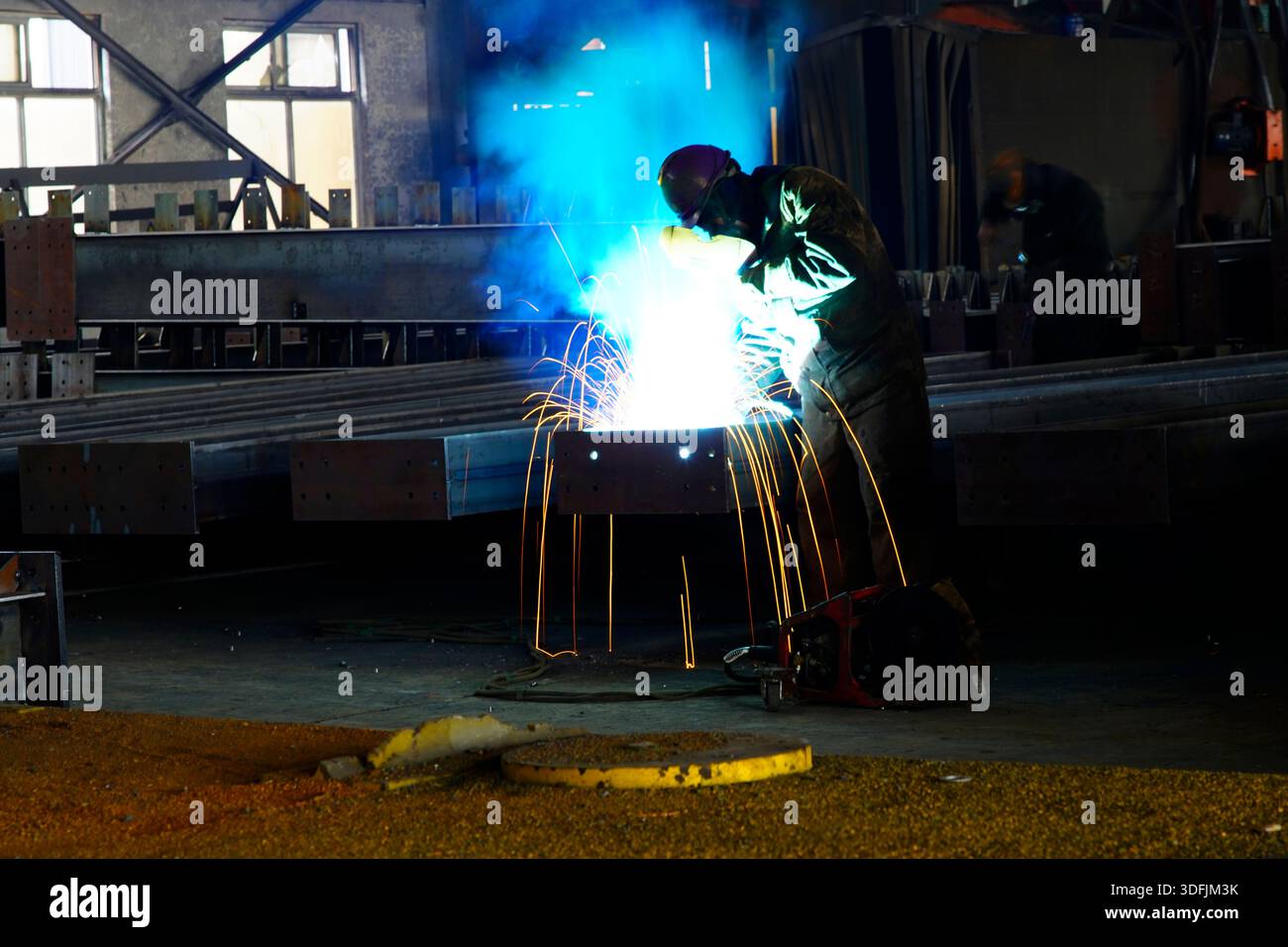 In the industrial workshop, welders wear protective equipment to weld ...