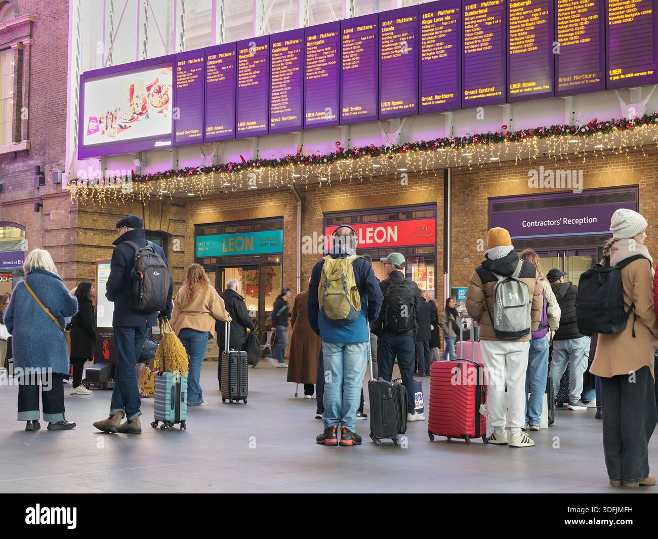 Travellers scan the notice board at King's Cross railway station ...