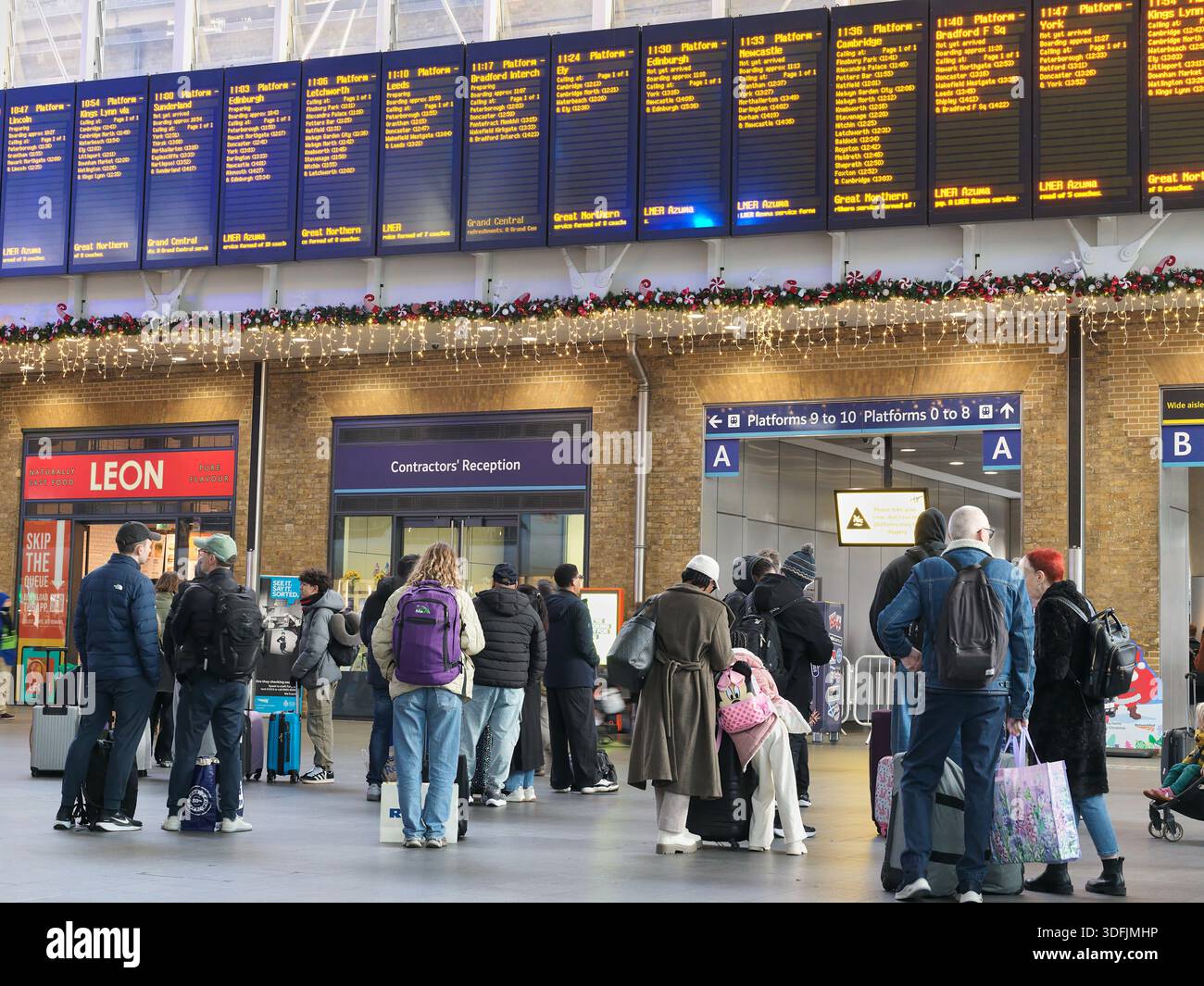 Travellers scan the notice board at King's Cross railway station ...
