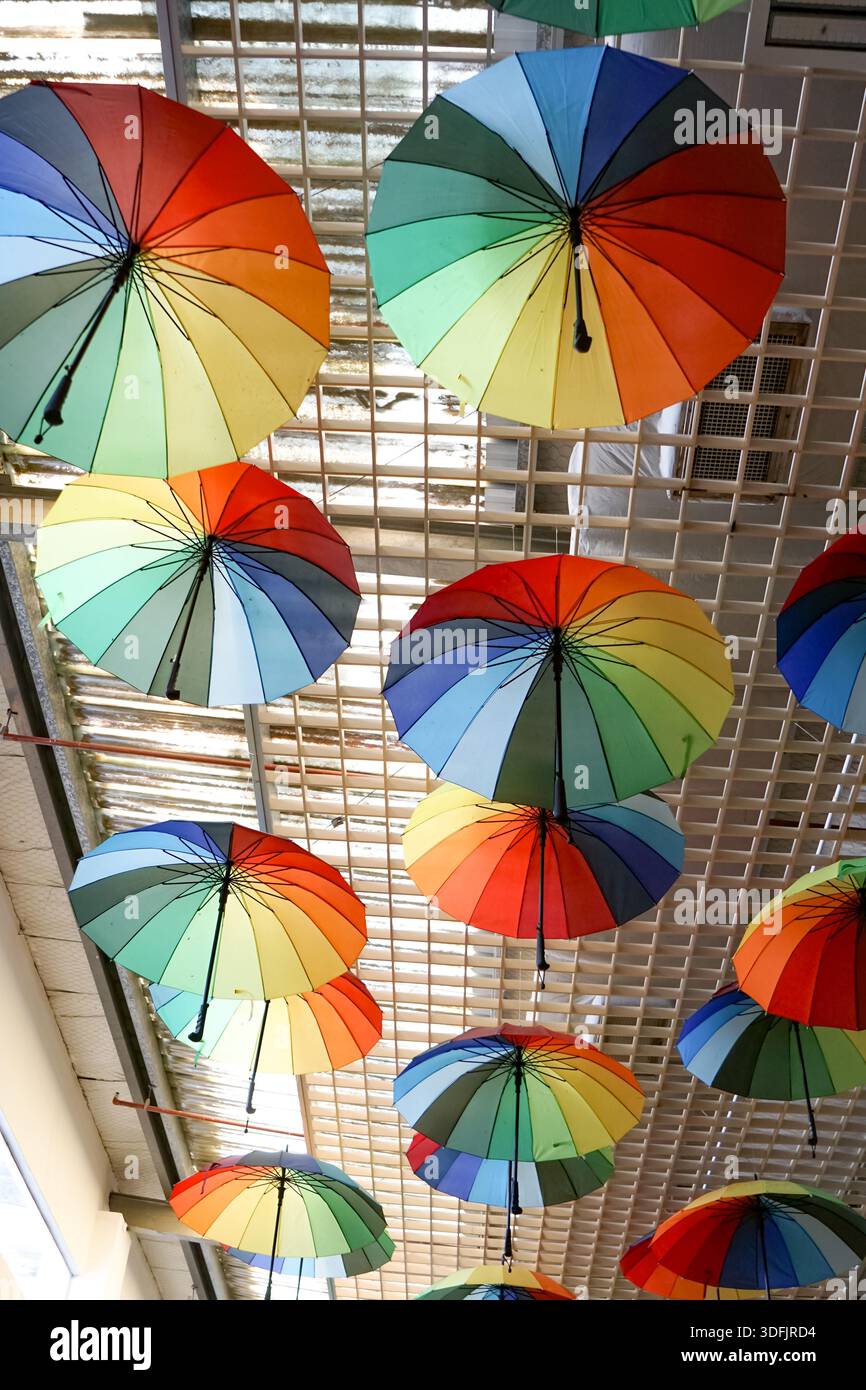 Vibrant umbrellas arranged in rows against a grid background, creating ...