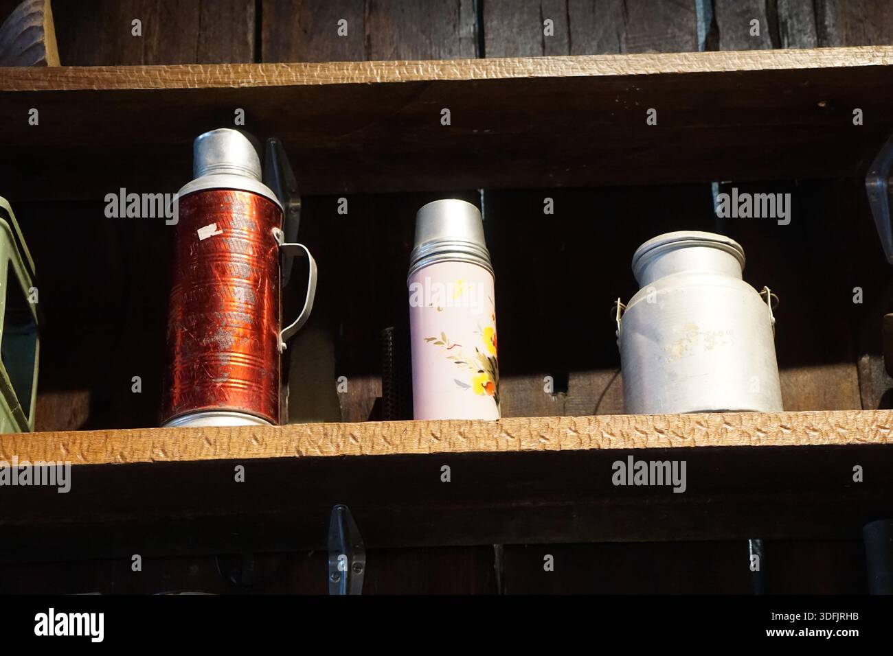 Three retro beverage containers—two thermoses and a milk can—arranged ...