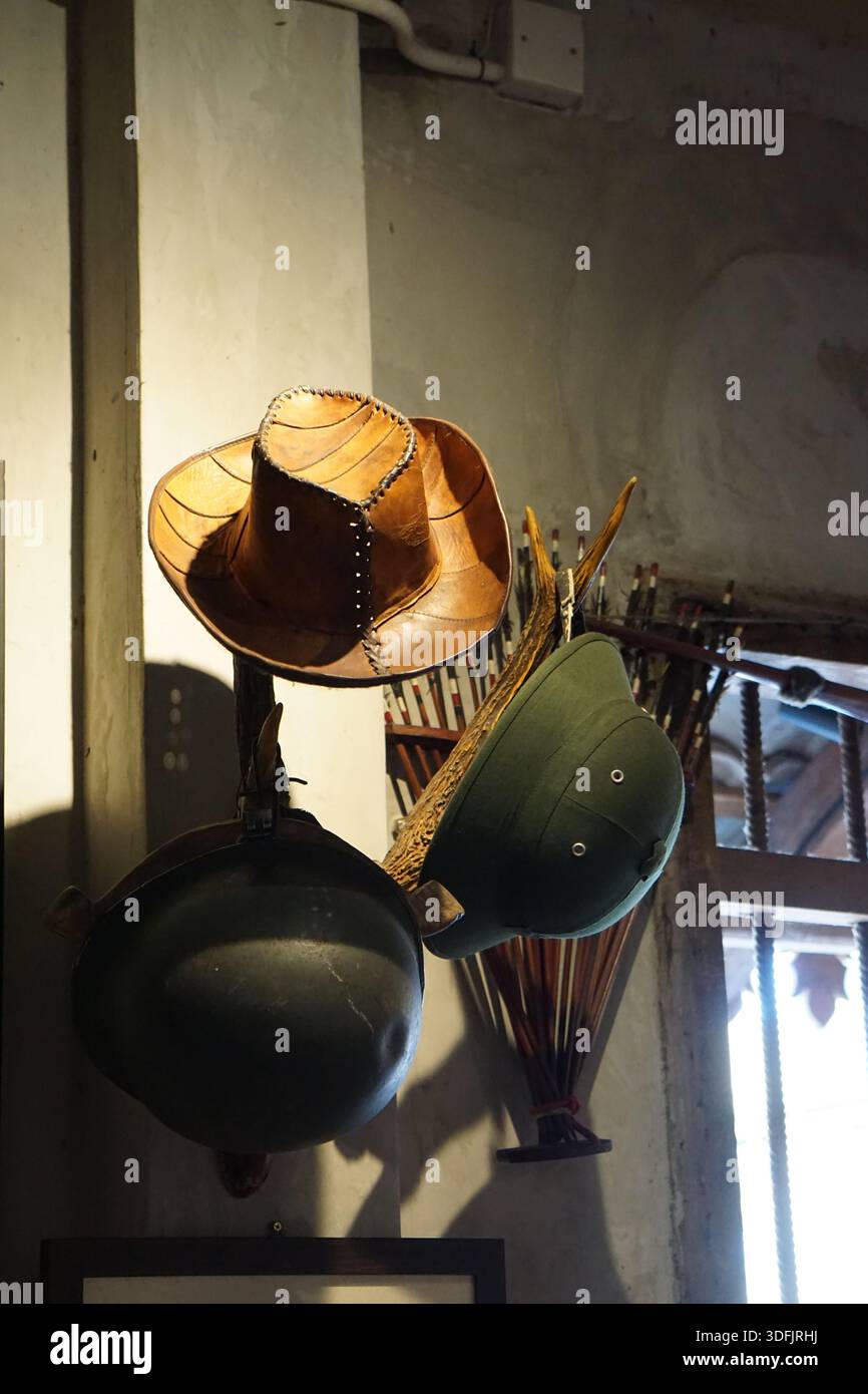 Three distinct vintage hats—a military helmet, cowboy hat, and pith ...