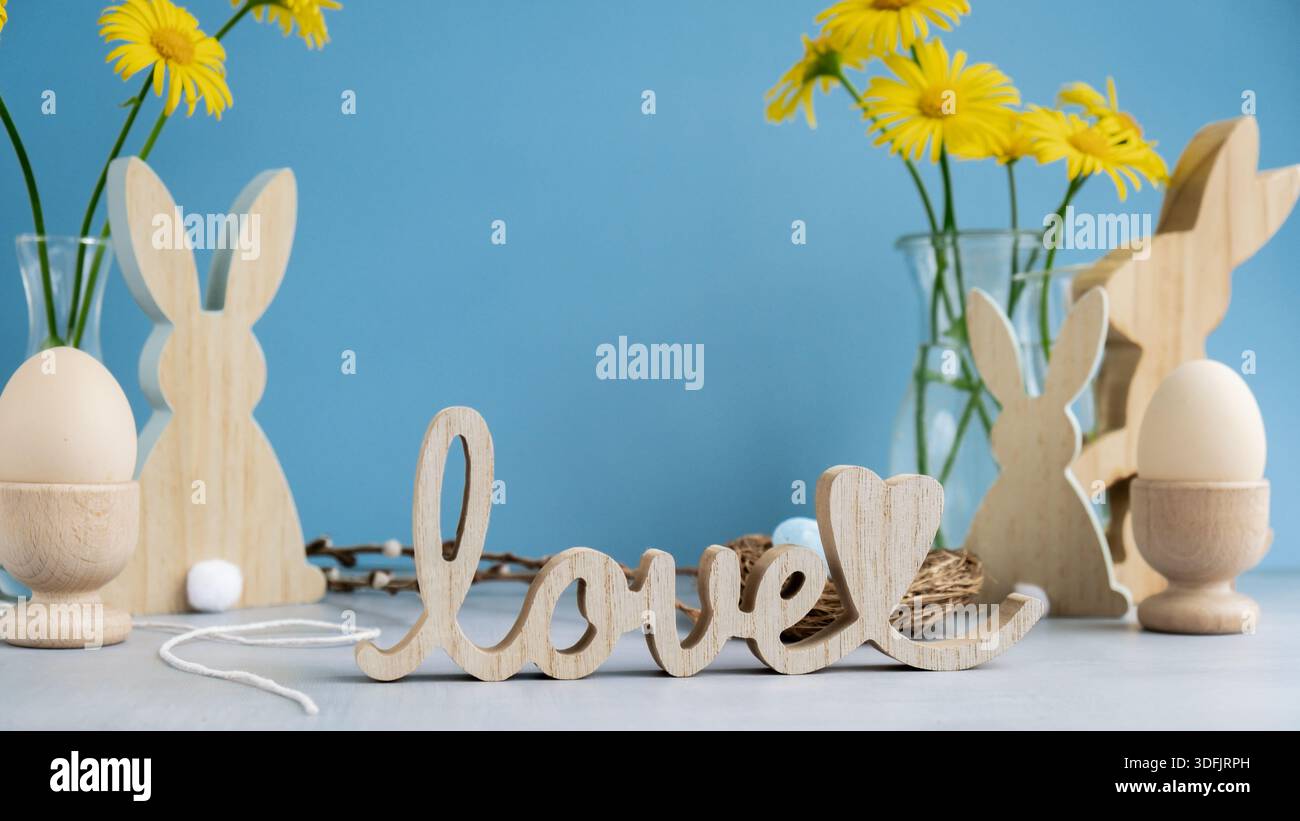 Wooden word LOVE with bunny figures eggs and fresh flowers. Easter ...