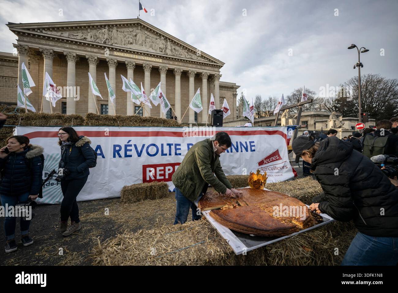 Farmers cut a giant King's cake during a demonstration in front of the ...