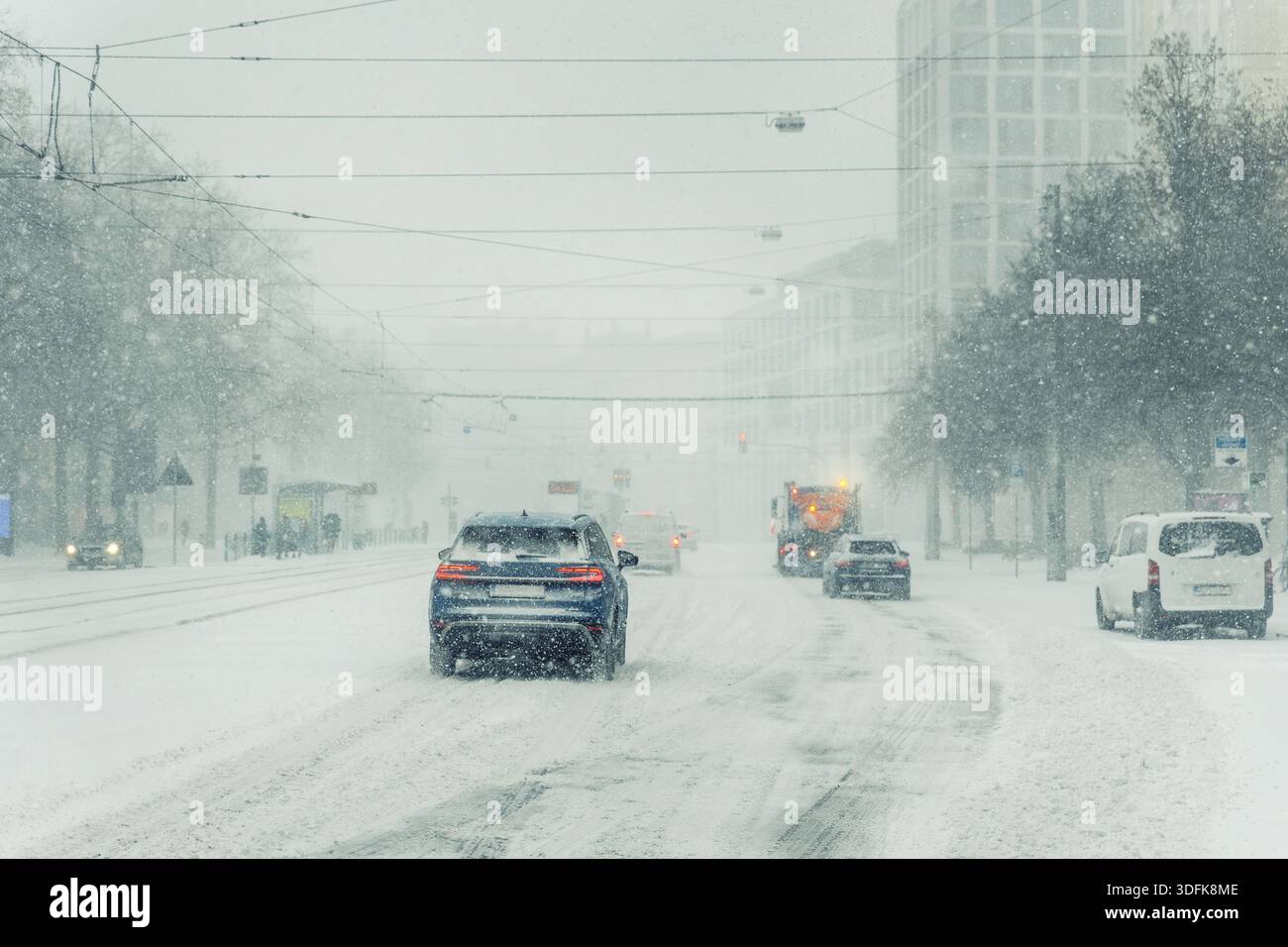 Heavy snowfall cover urban street Magdeburg car service truck move low ...