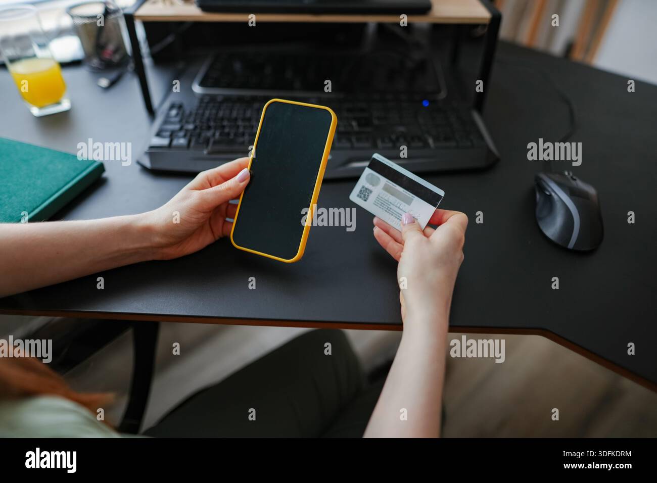 Holding a smartphone and credit card at a modern workspace Stock Photo ...