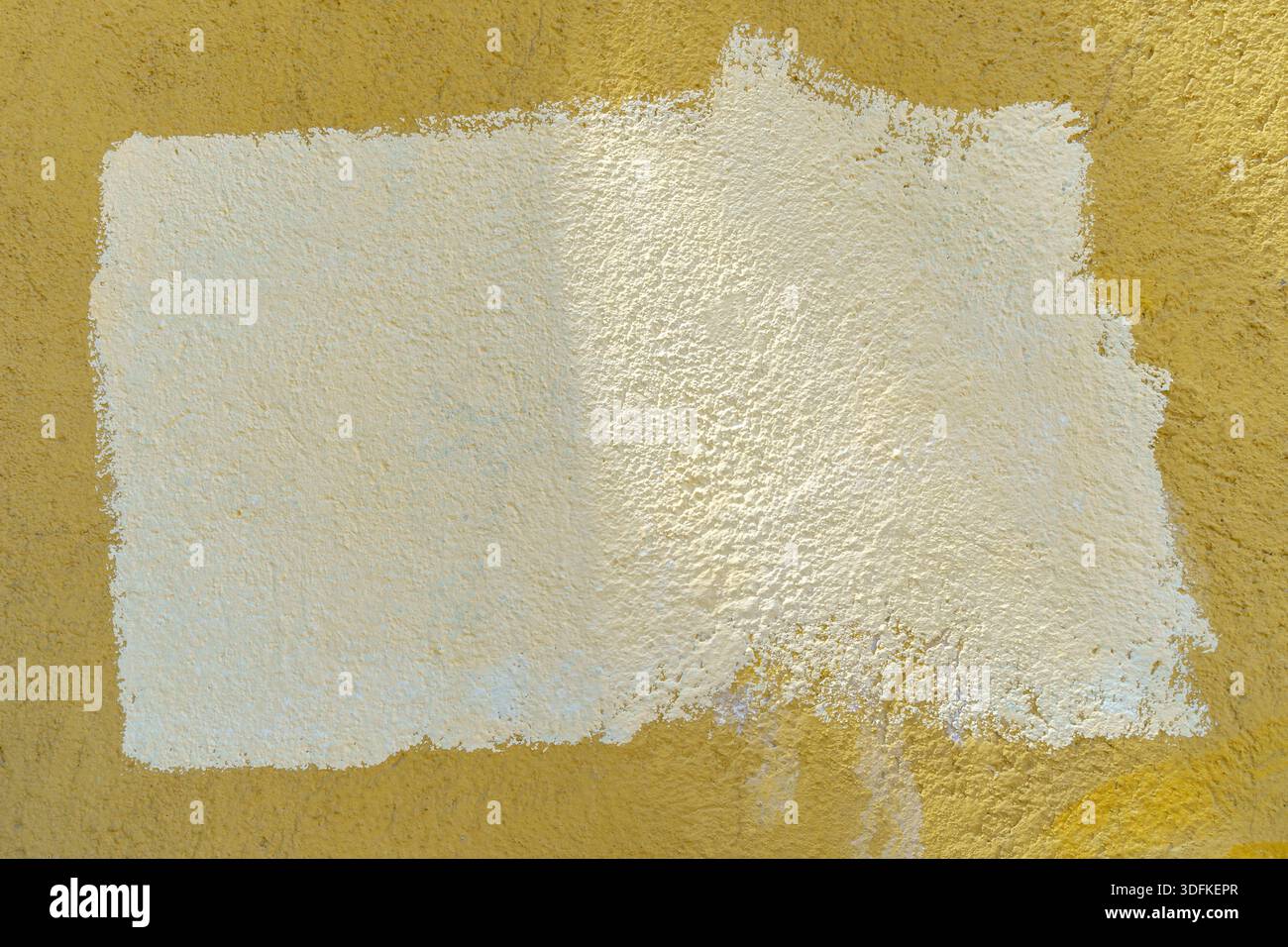 White rectangular spot of paint on a yellow wall. Abstract design ...