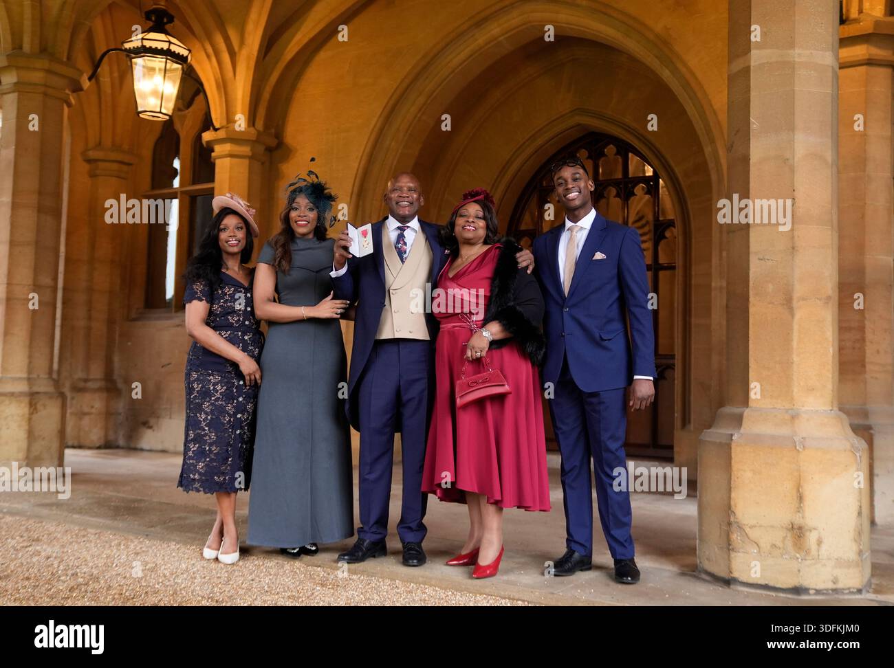 Devon Malcolm (centre) with family members after being made an Officer ...