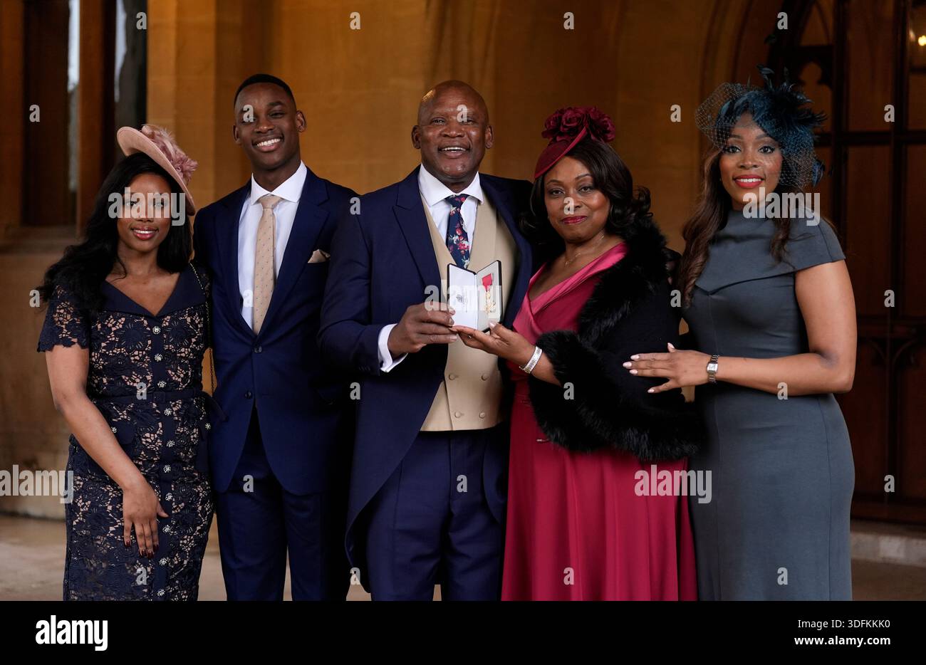 Devon Malcolm (centre) with family members after being made an Officer ...