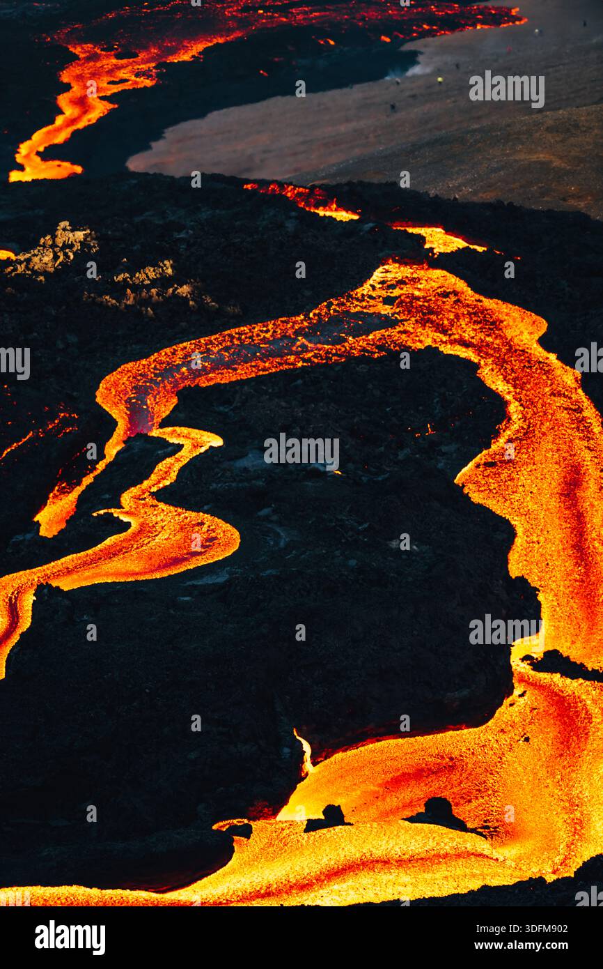 View of fiery rivers of molten lava snaking through the dark, cooled ...