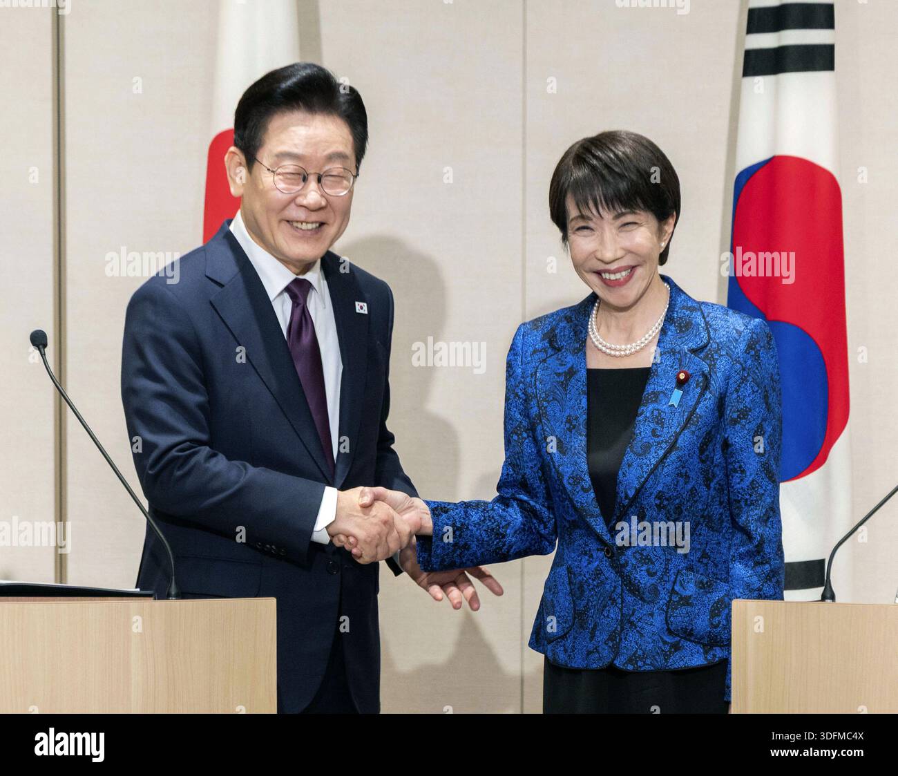 Japanese Prime Minister Sanae Takaichi (R) shakes hands with South ...