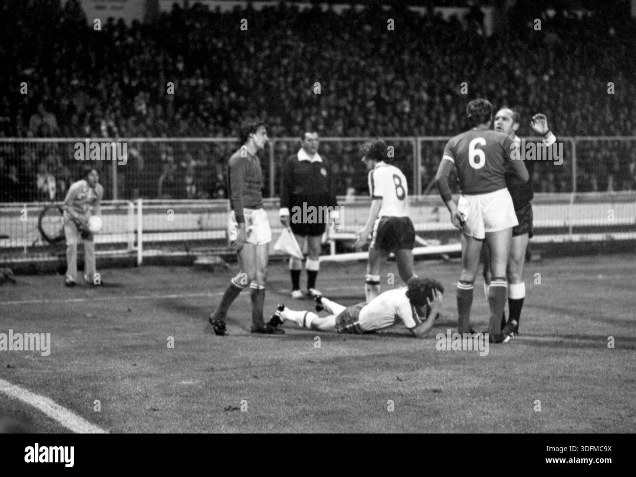 England's Kevin Keegan lies injured, while the Hungarian referee Karoly ...