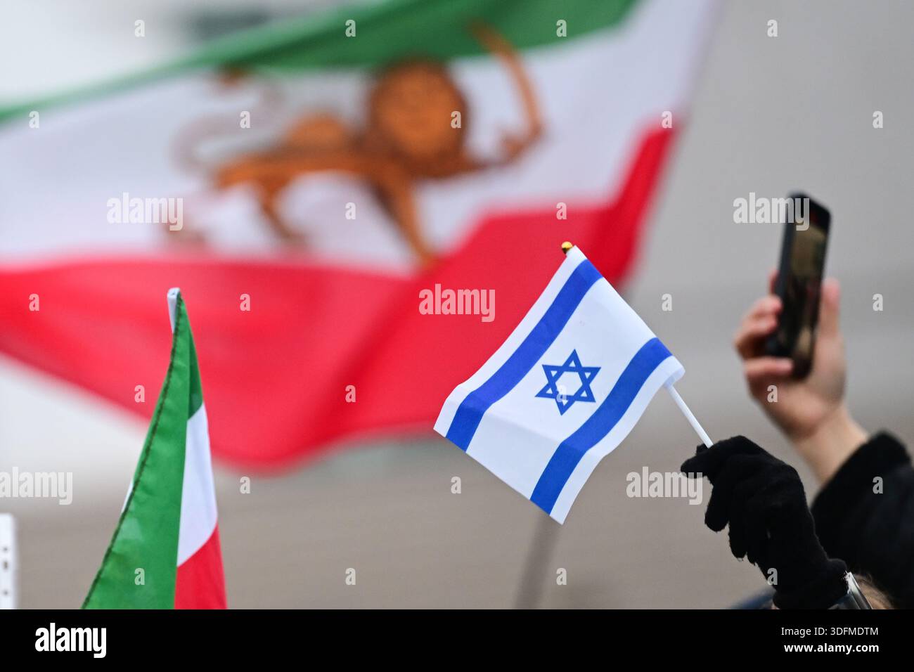 13 January 2026, Berlin: A woman holds an Israeli flag in front of an ...