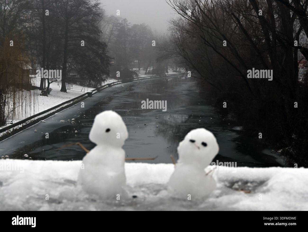 13 January 2026, Berlin: Two small snowmen stand on the railing of the ...