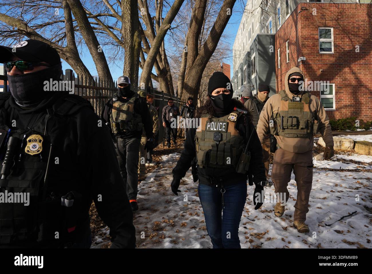 Federal law enforcement agents walk through an apartment block on ...