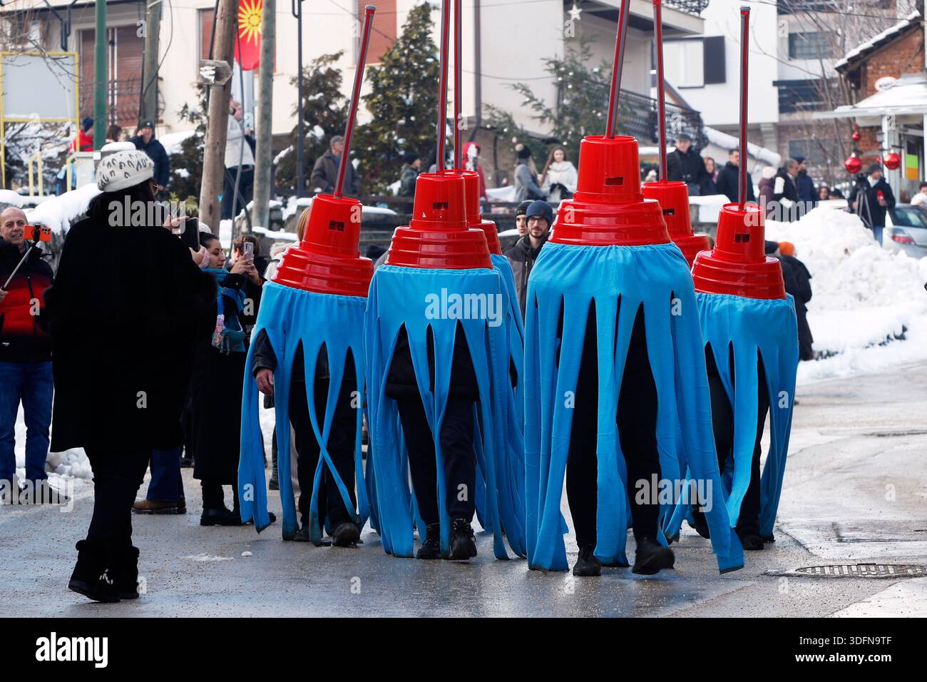 Costumed revelers walk through the village of Vevcani in the ...