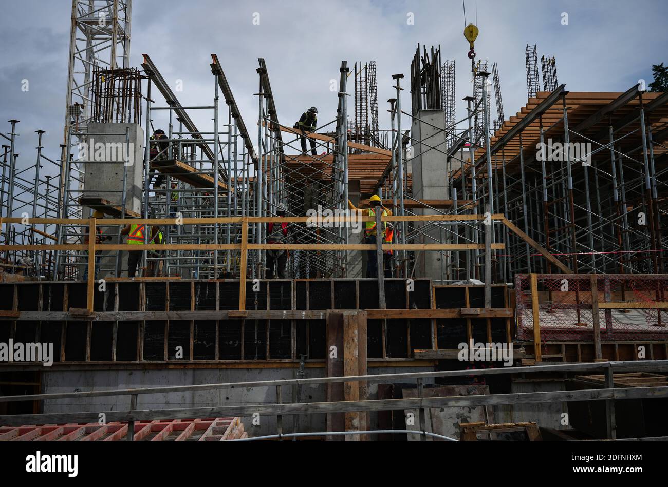 Construction workers work at the site of a condo tower under ...