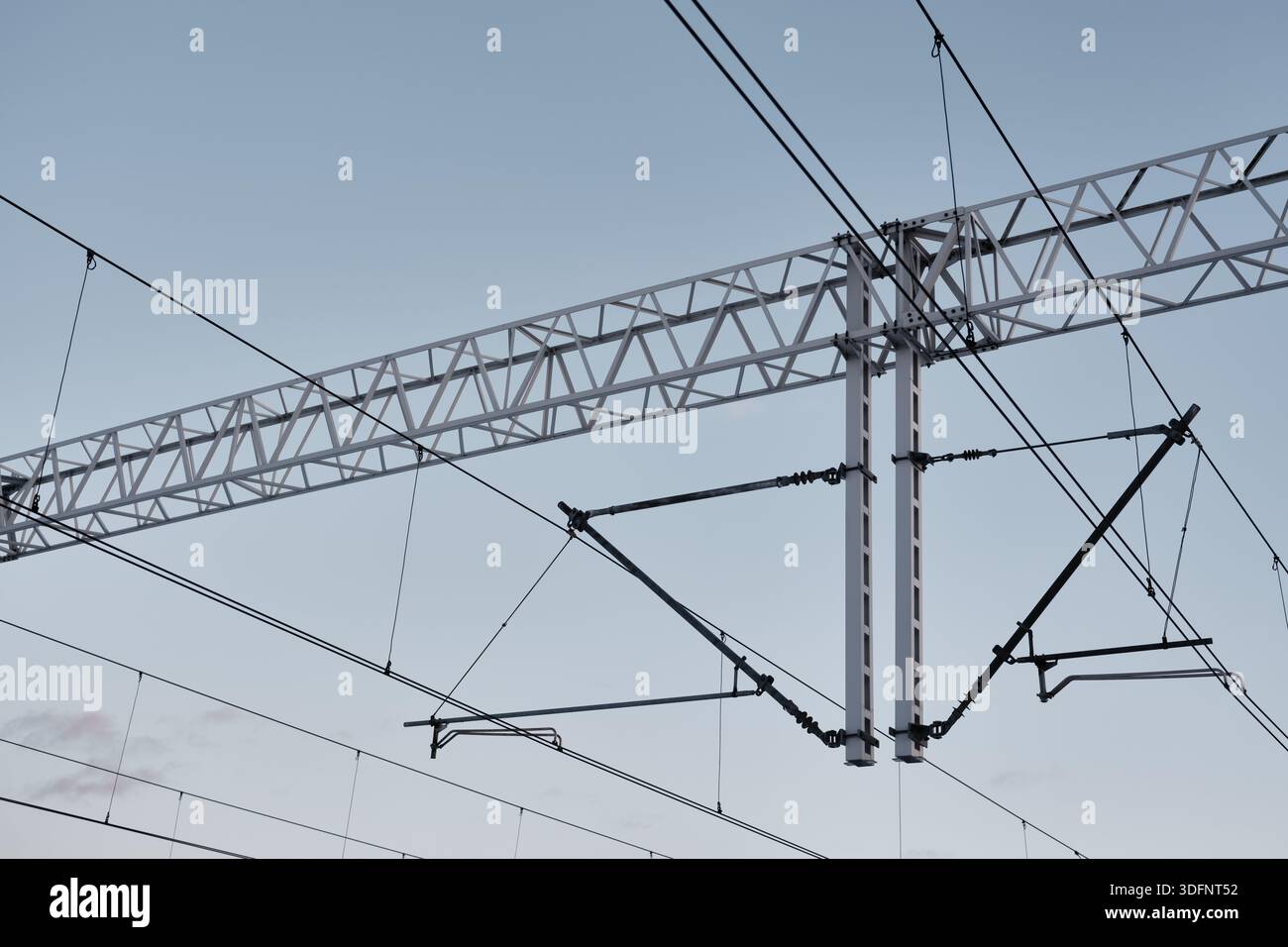 Overhead railway catenary and power lines against blue sky, electrified ...