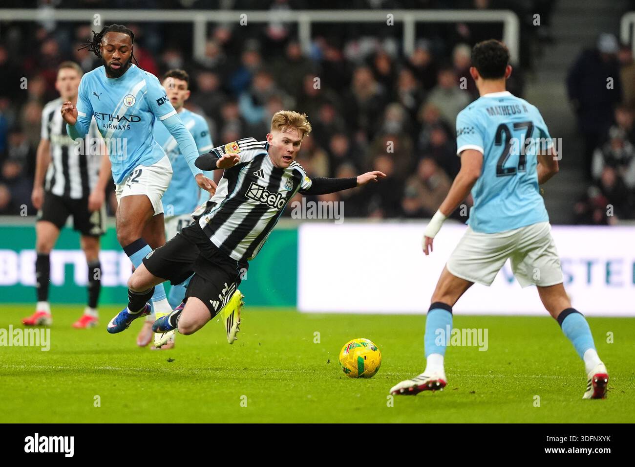 Newcastle United's Lewis Hall (centre) is challenged by Manchester City ...