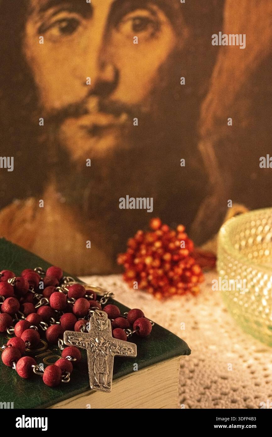 Jesus Christ's image provides a spiritual backdrop for a rosary draped ...