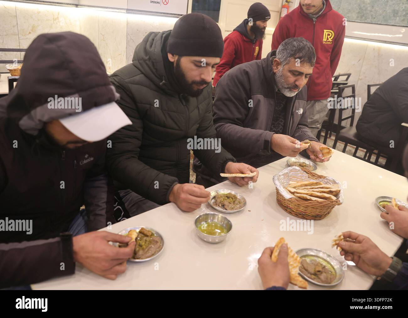 SRINAGAR, INDIA - JANUARY 13: People eat Harissa a traditional Kashmiri ...