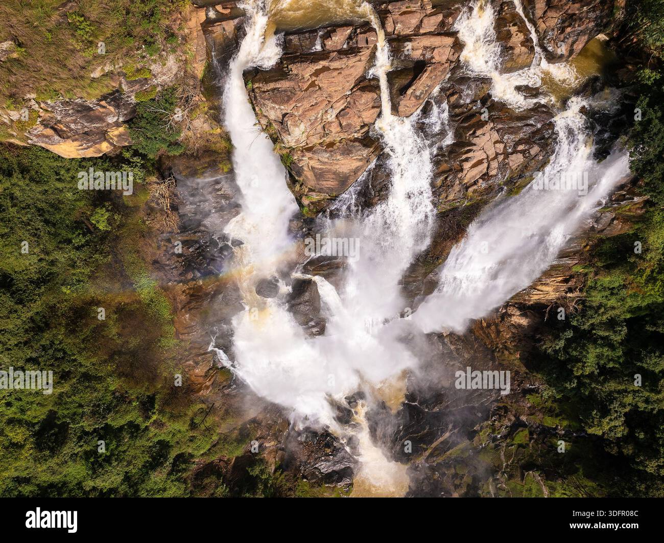 Aerial view of Powerful Bomburu Ella Waterfall Cascading Over Dark Rock ...