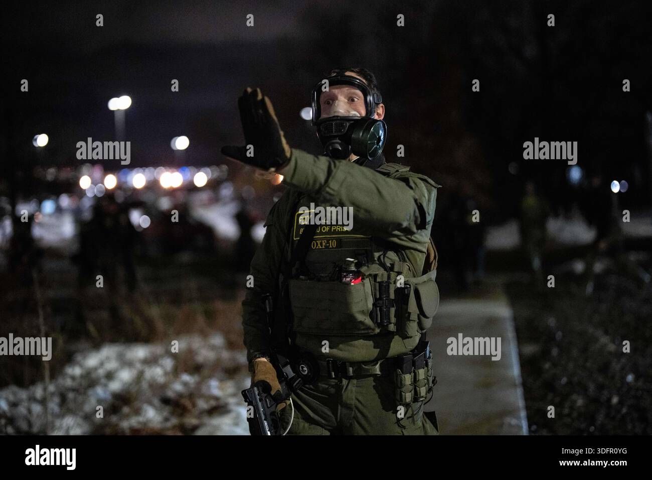 A federal officer urges the crowd back as they detain a person outside ...