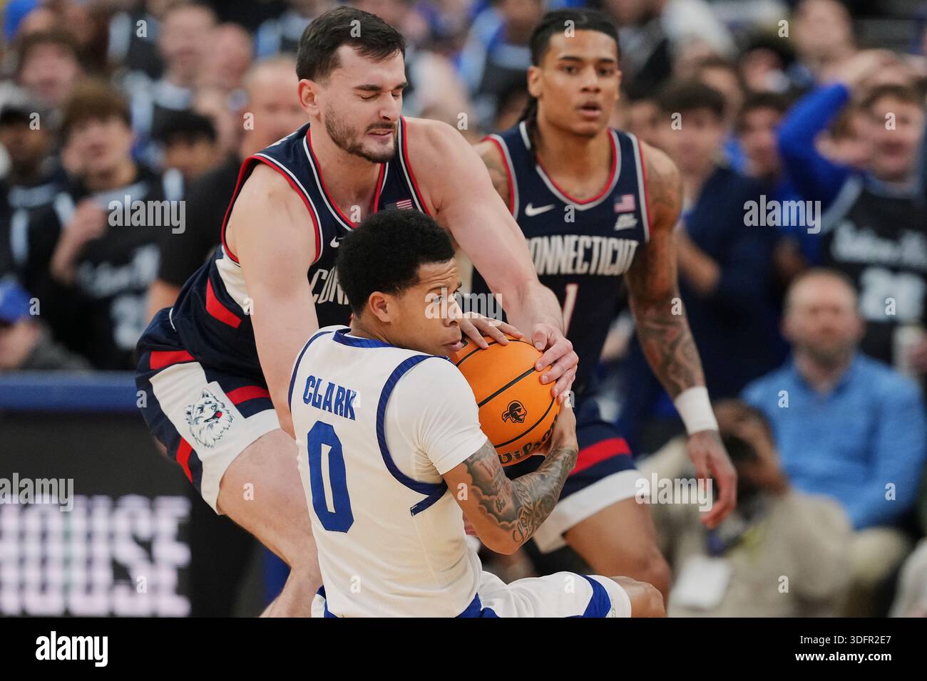 Seton Hall's Adam Clark (0) fights for control of the ball with UConn's ...