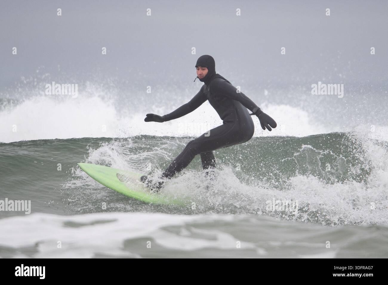 HAMPTON, NH - JANUARY 11: A surfer rides a wave on January 11, 2026, at ...