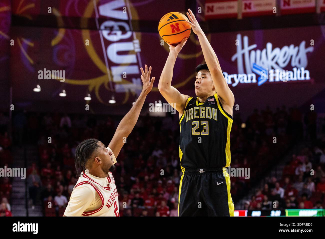 Oregon guard Wei Lin (23) shoots over Nebraska guard Kendall Blue (2 ...
