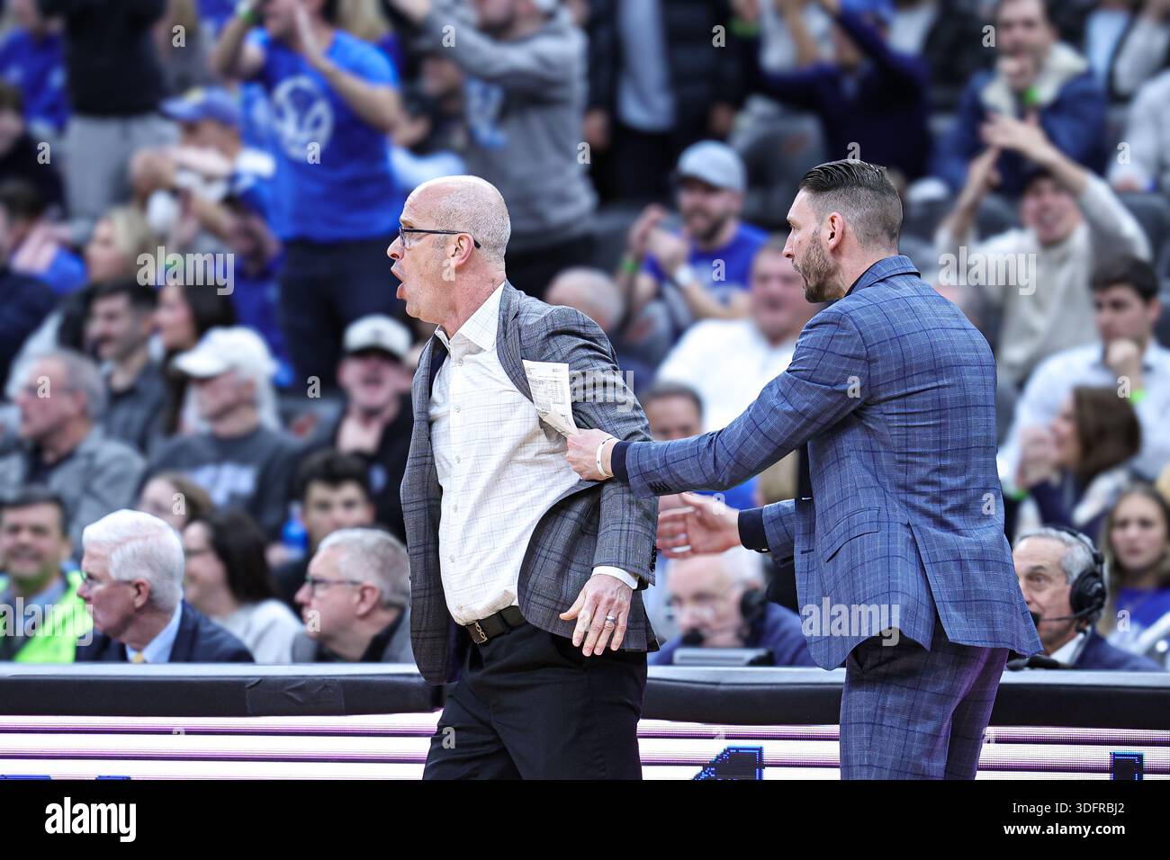 UConn Huskies head coach Dan Hurley being held back by an assistant ...