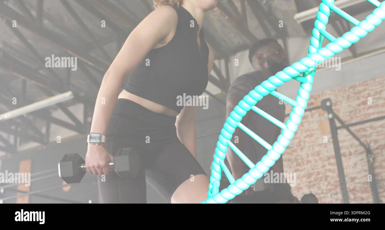 Holding hex dumbbell, female exerciser lunging at gym in black crop top ...