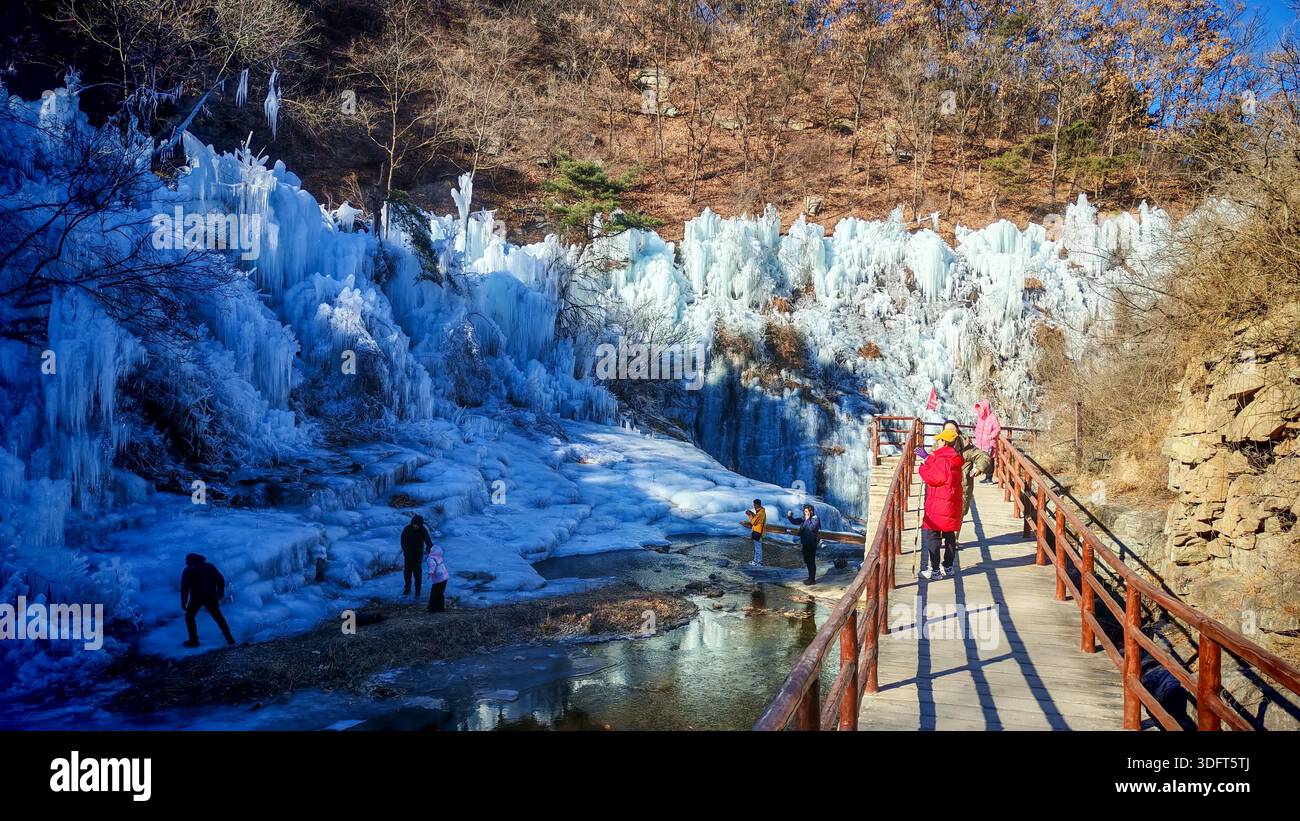 Tourists admire the spectacular ice waterfall scenery of Longtan Grand ...