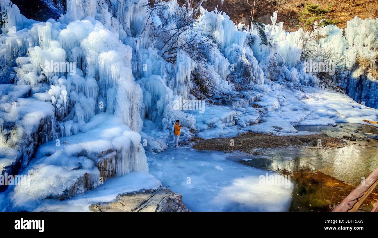 Tourists admire the spectacular ice waterfall scenery of Longtan Grand ...