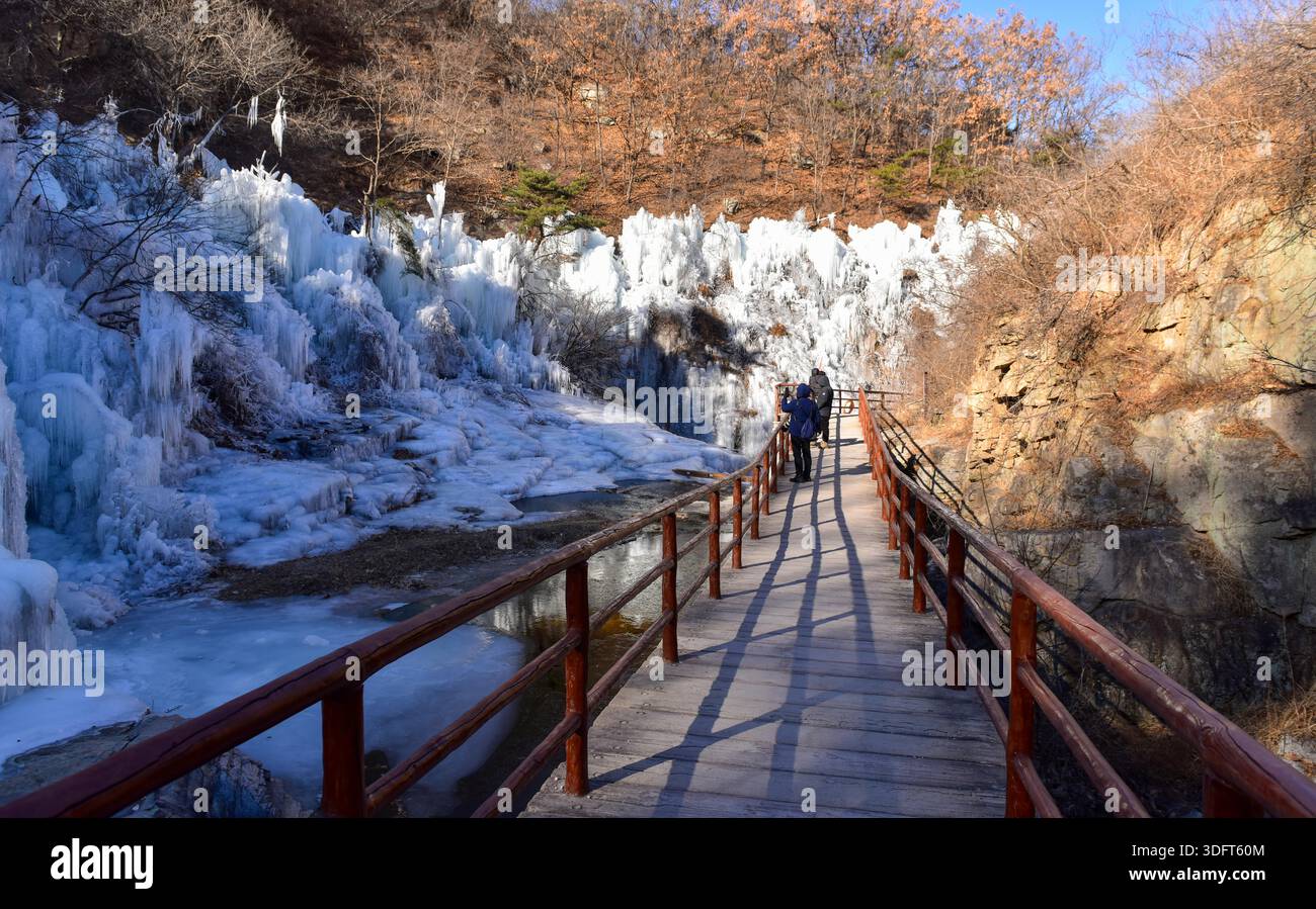 Tourists admire the spectacular ice waterfall scenery of Longtan Grand ...