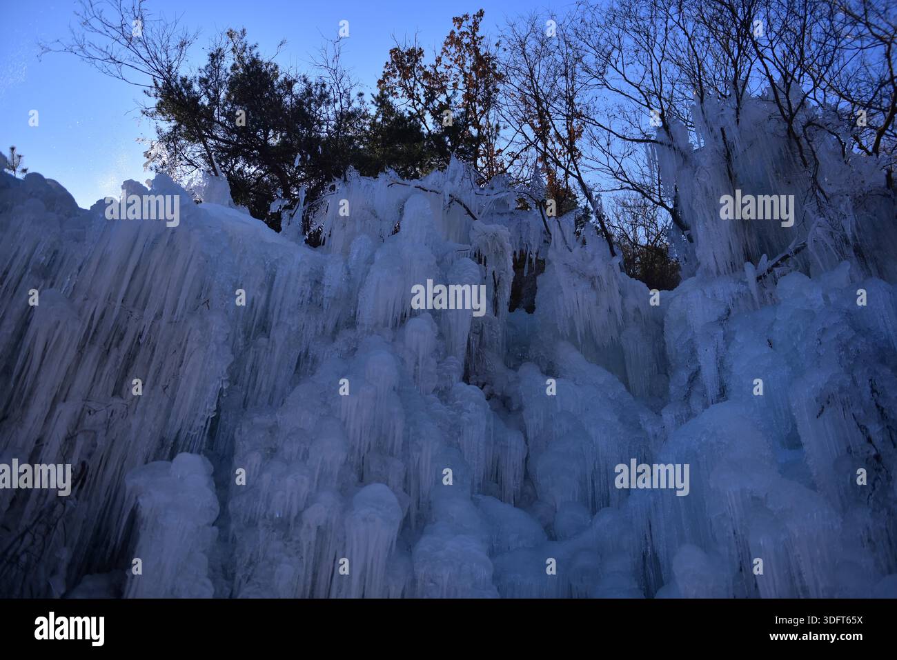 Tourists admire the spectacular ice waterfall scenery of Longtan Grand ...