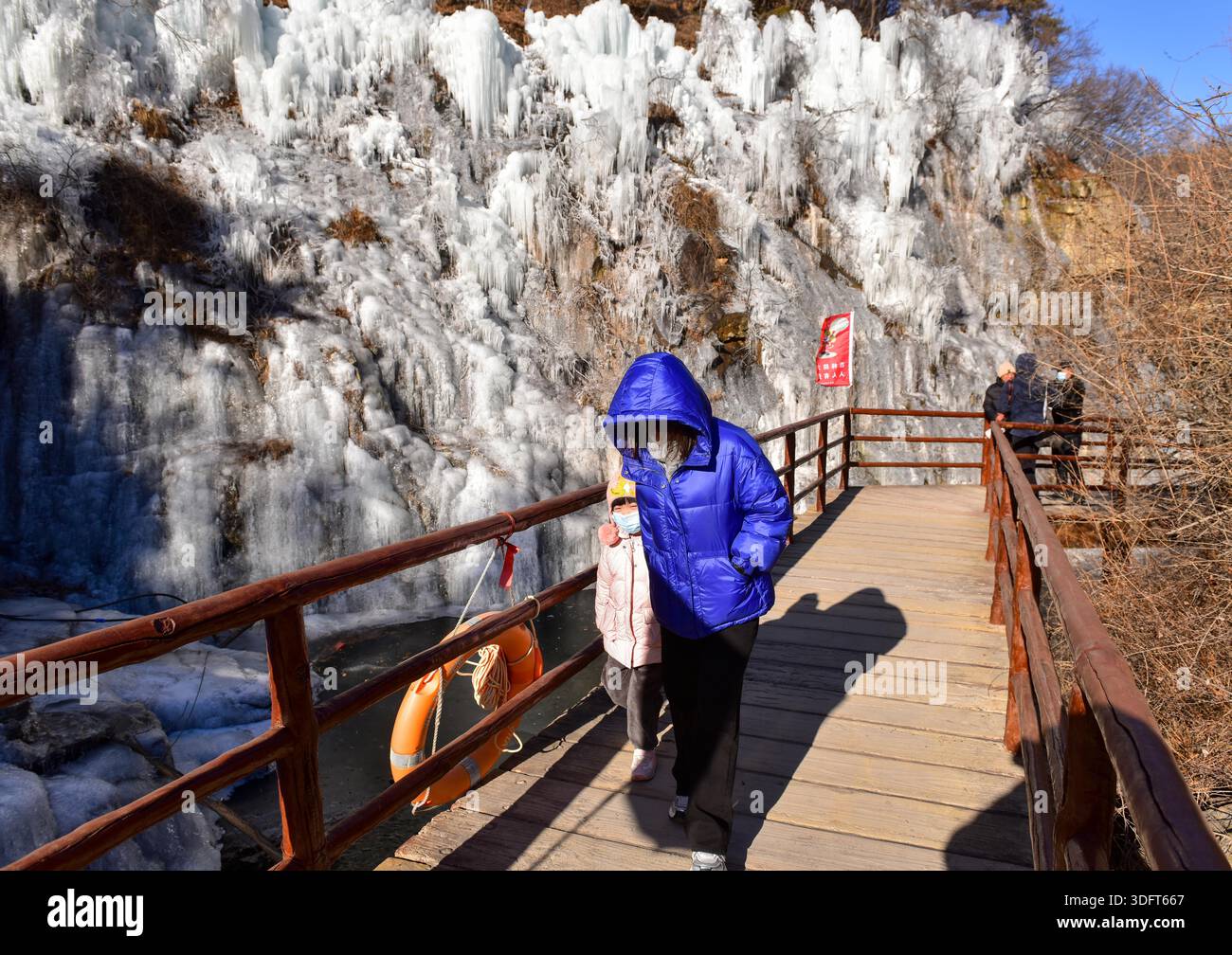 Tourists admire the spectacular ice waterfall scenery of Longtan Grand ...