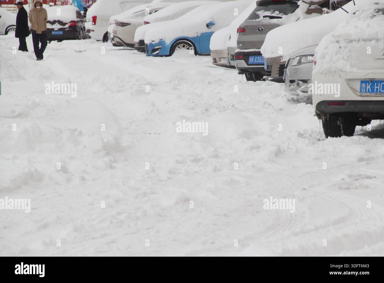 Vehicles are covered with snow after a snowstorm in Weihai City, east ...