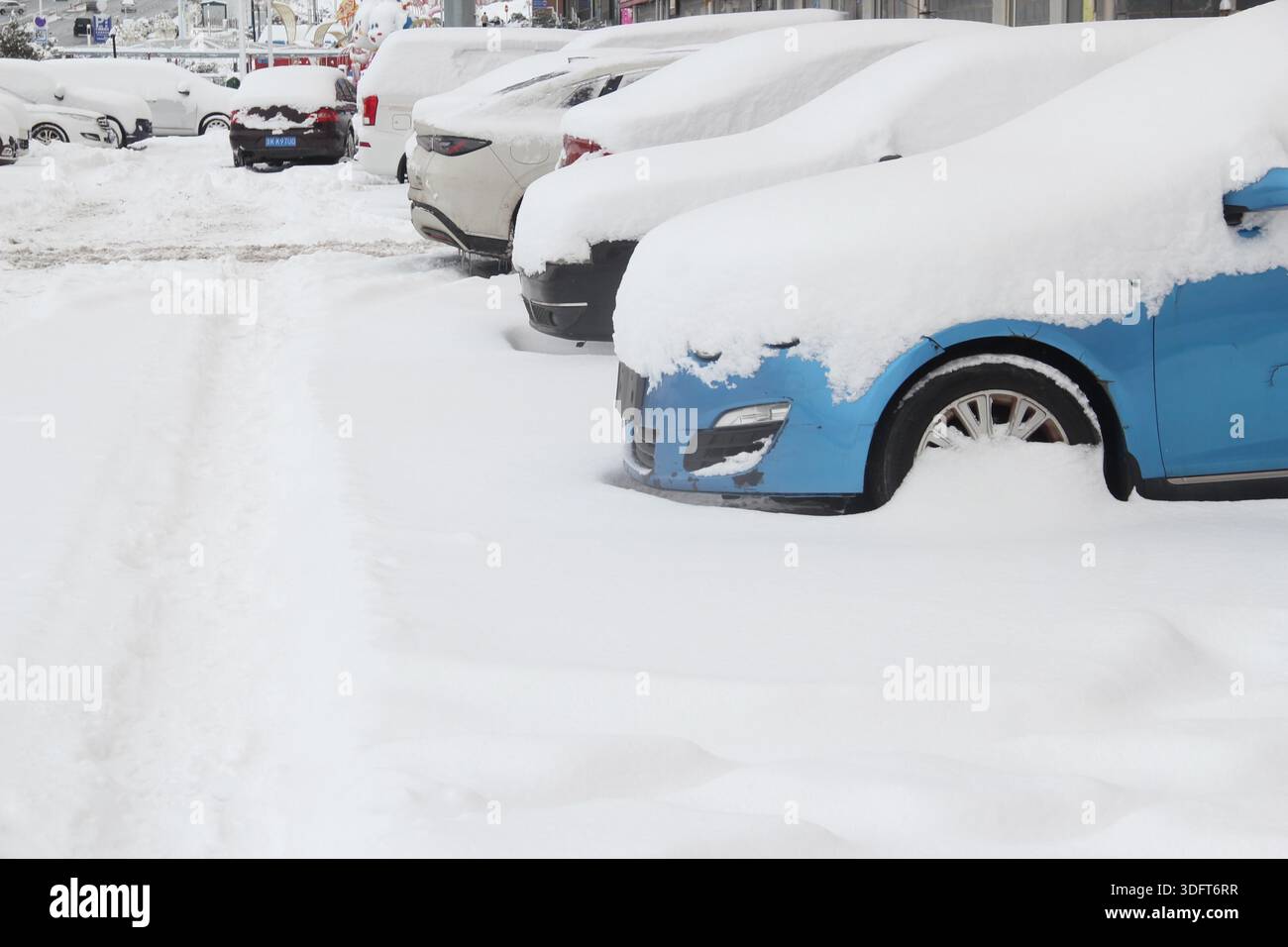 Vehicles are covered with snow after a snowstorm in Weihai City, east ...