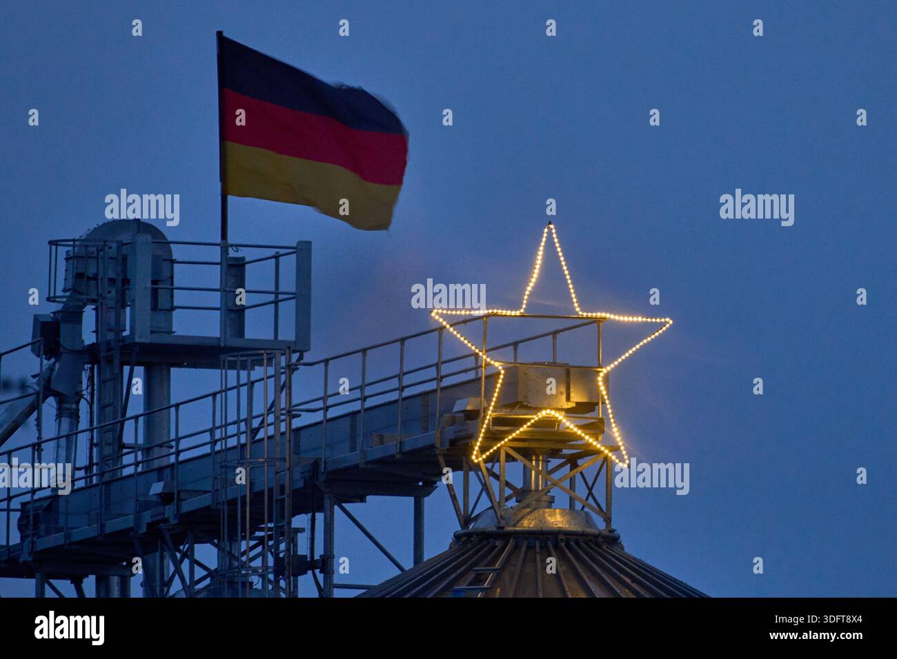 A Christmas star and a German flag are fixed on a silo of a farm in ...
