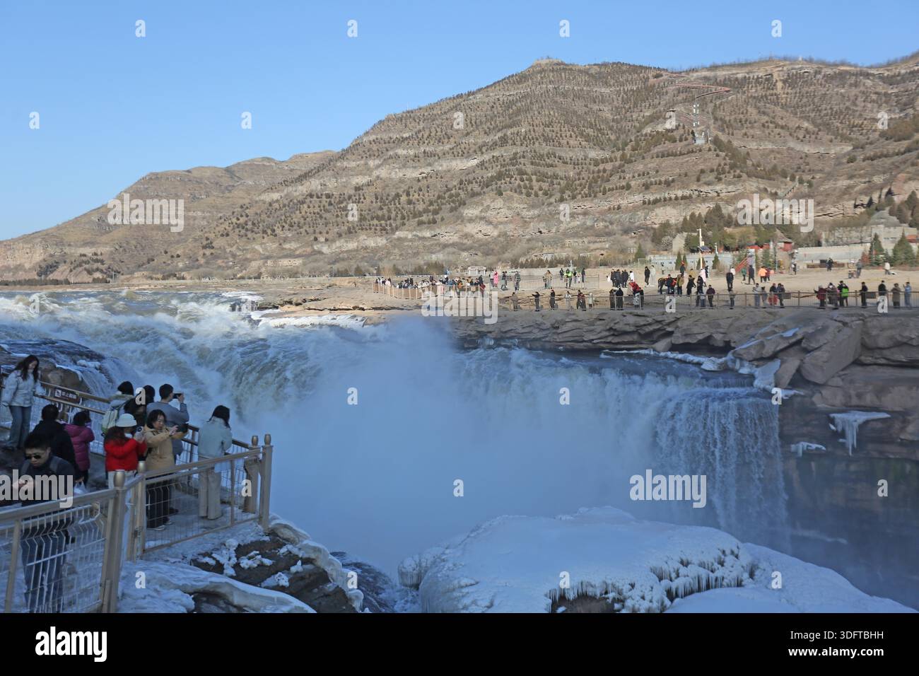 Tourists visit the Hukou Waterfall scenic area in Linfen City, north ...