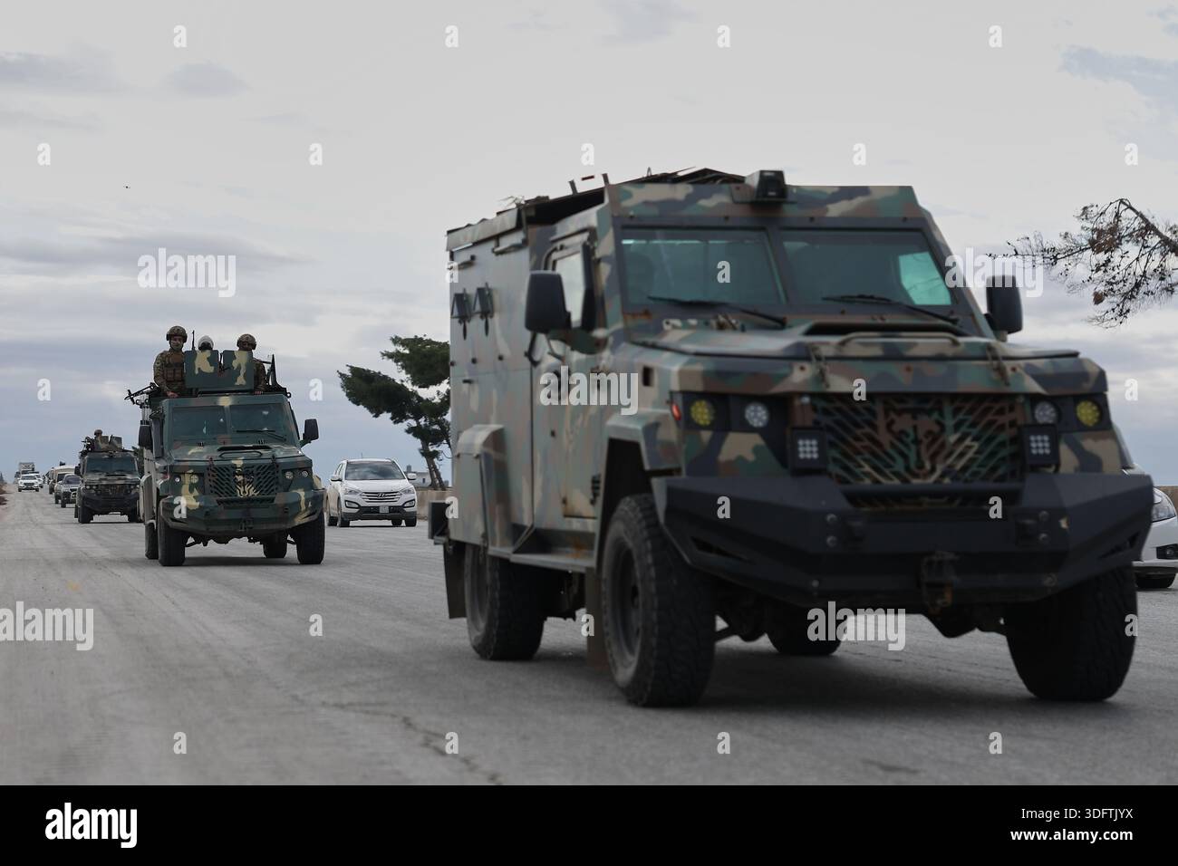 A convoy of Syrian government forces passes on a highway on their way ...
